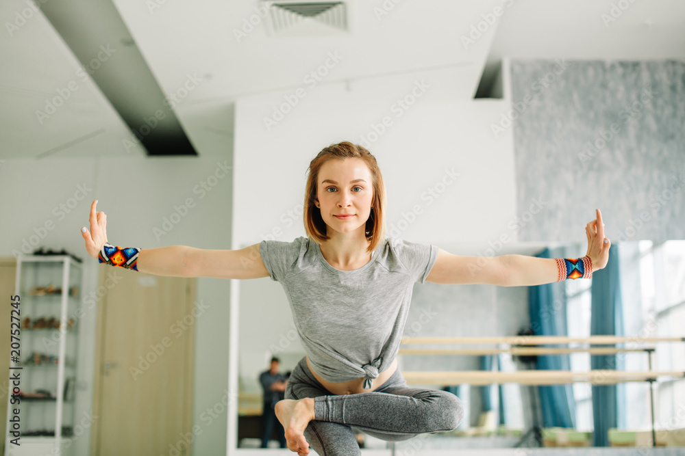 Woman doing balancing exercises during a yoga workout adopting a hand ...