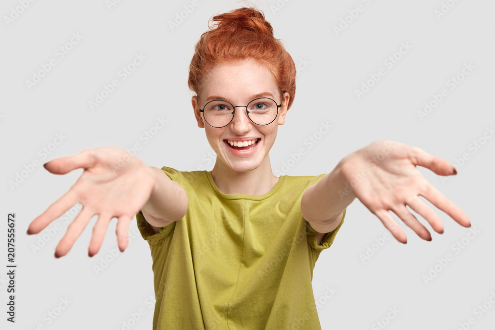 Horizontal shot of happy friendly Caucasian female has foxy hair, gives ...