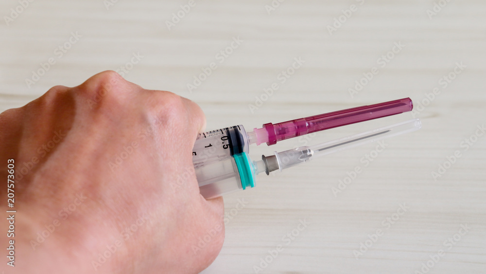 A hand holding two syringes. Be careful when using syringes. Stock ...
