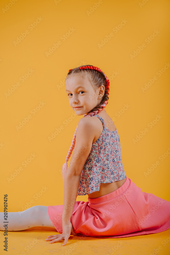Cute little girl with long thin braids on his head sitting on the floor ...