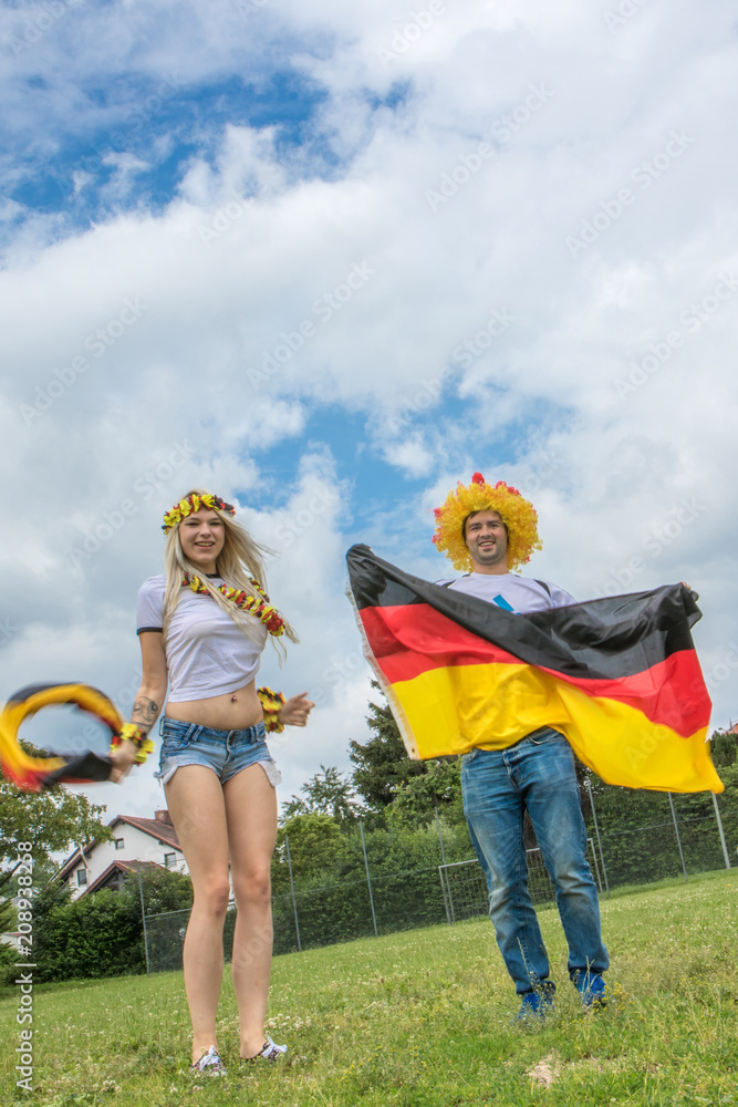 Paar Fussballfan auf Wiese freuen sich über den Sieg der deutschen ...