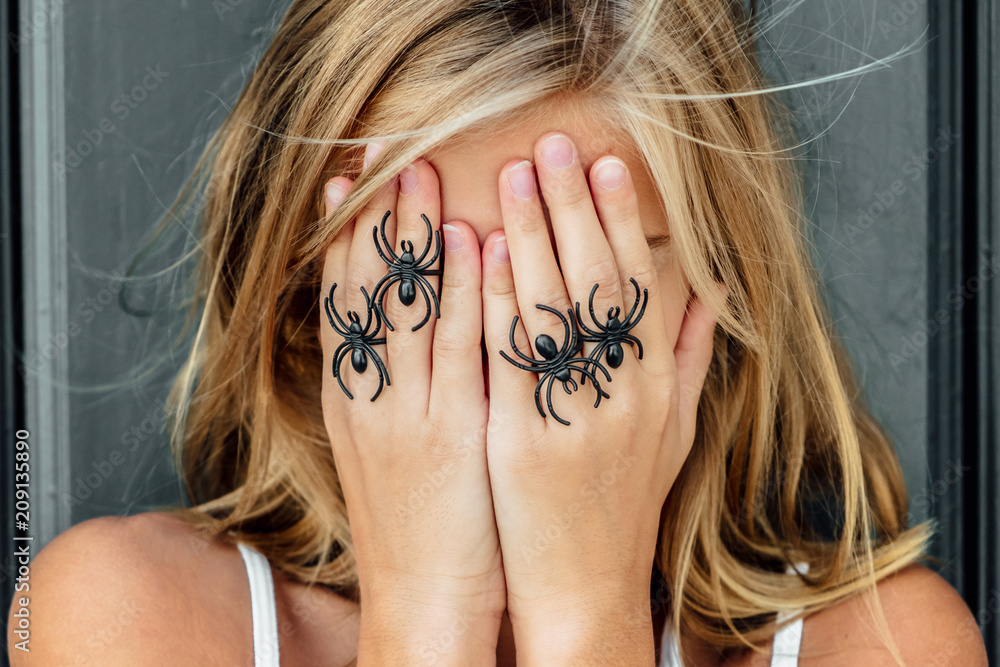 Girl posing with fake spiders Stock Photo | Adobe Stock