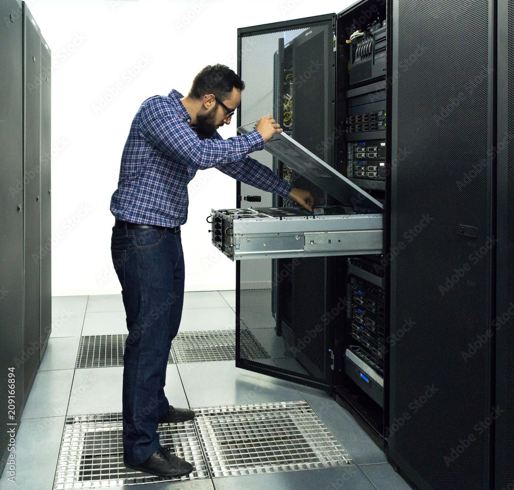 Technician performing maintenance tasks in a server room rack Stock ...