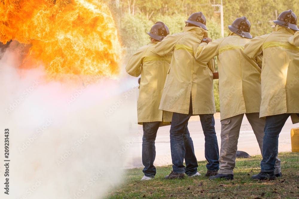 Firemen using water from hose for fire fighting at fire fight training ...