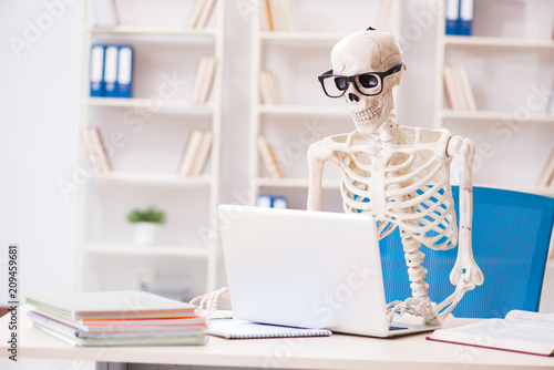 Skeleton businessman working in the office - Buy this stock photo and ...