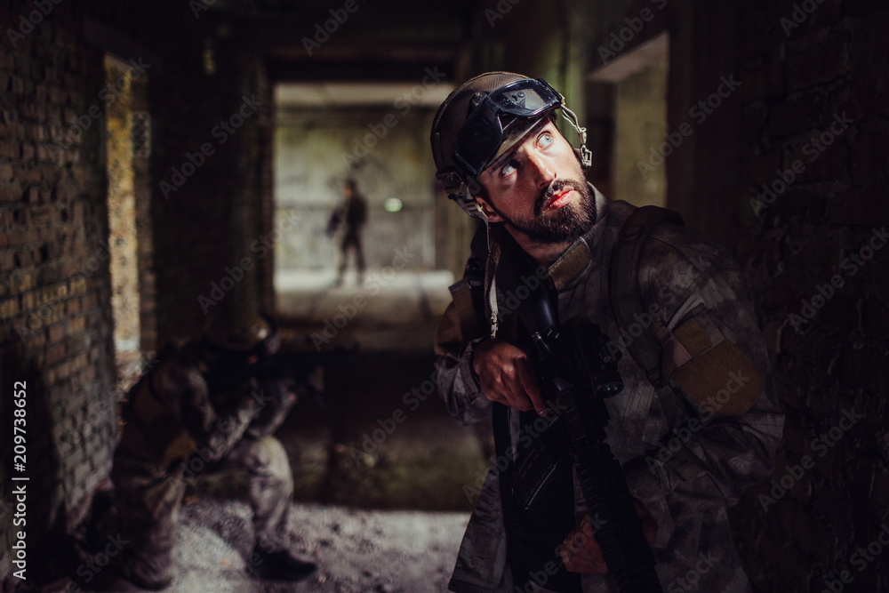 A picture of soldiers standing in dark corridor of empty building ...