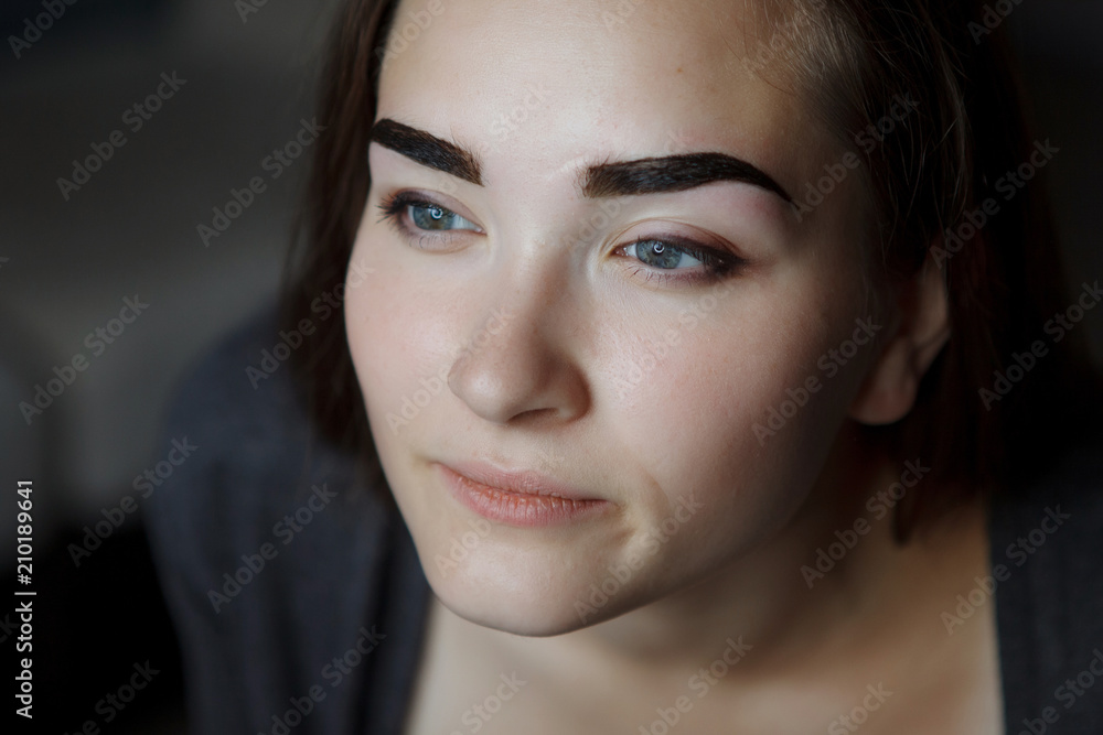 The make-up master models the shape of the eyebrows on the face of a ...