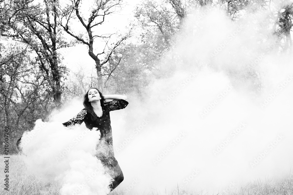 Young girl dancing in smoke covered forest Stock Photo | Adobe Stock