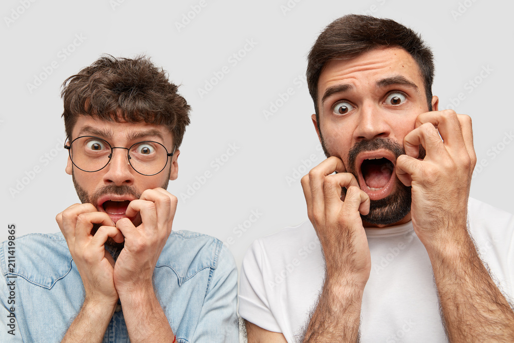 Foto de Stock Frightened two men have scared expressions, look nervously, notice terrible ...
