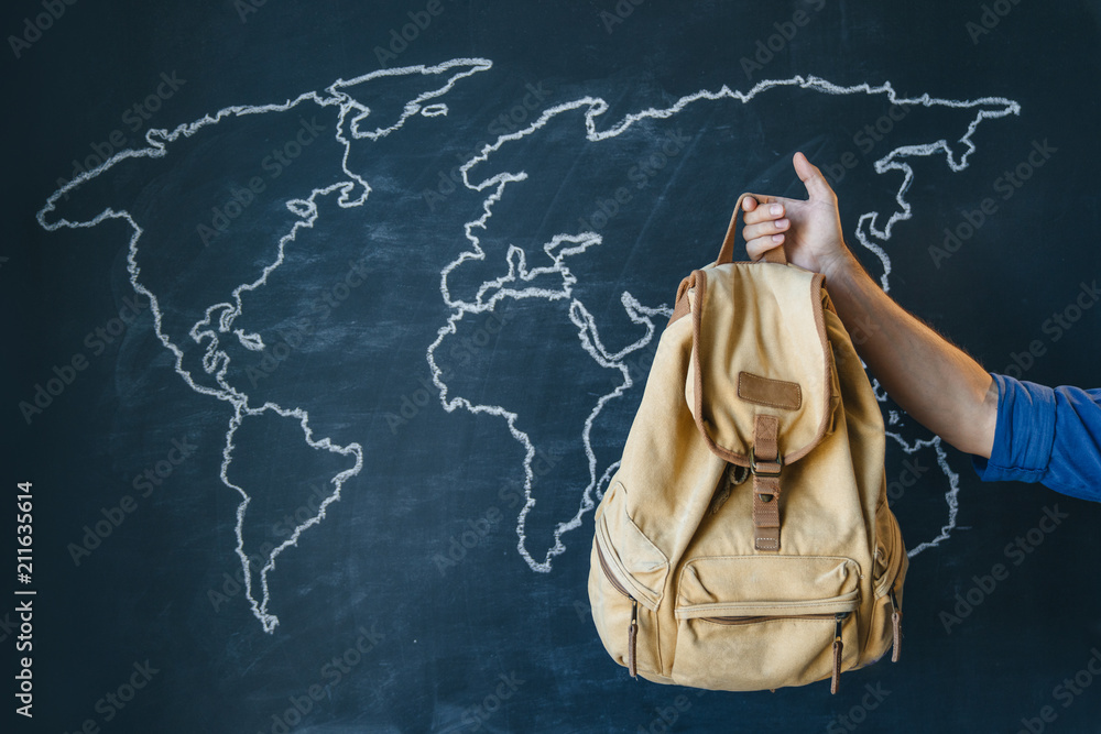 Rag yellow backpack for treks in a man's hand on a dark background of a ...
