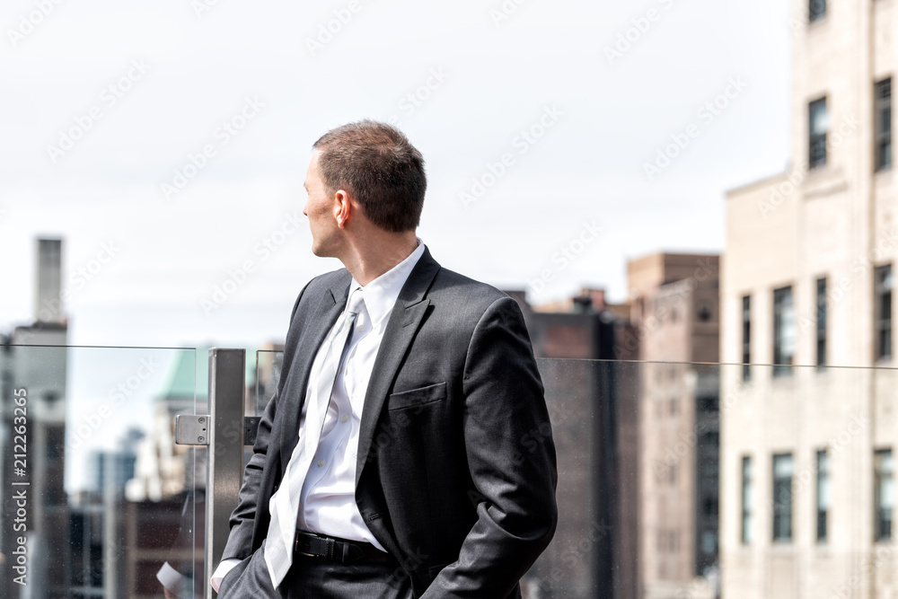 Young businessman standing in business suit looking over shoulder at ...