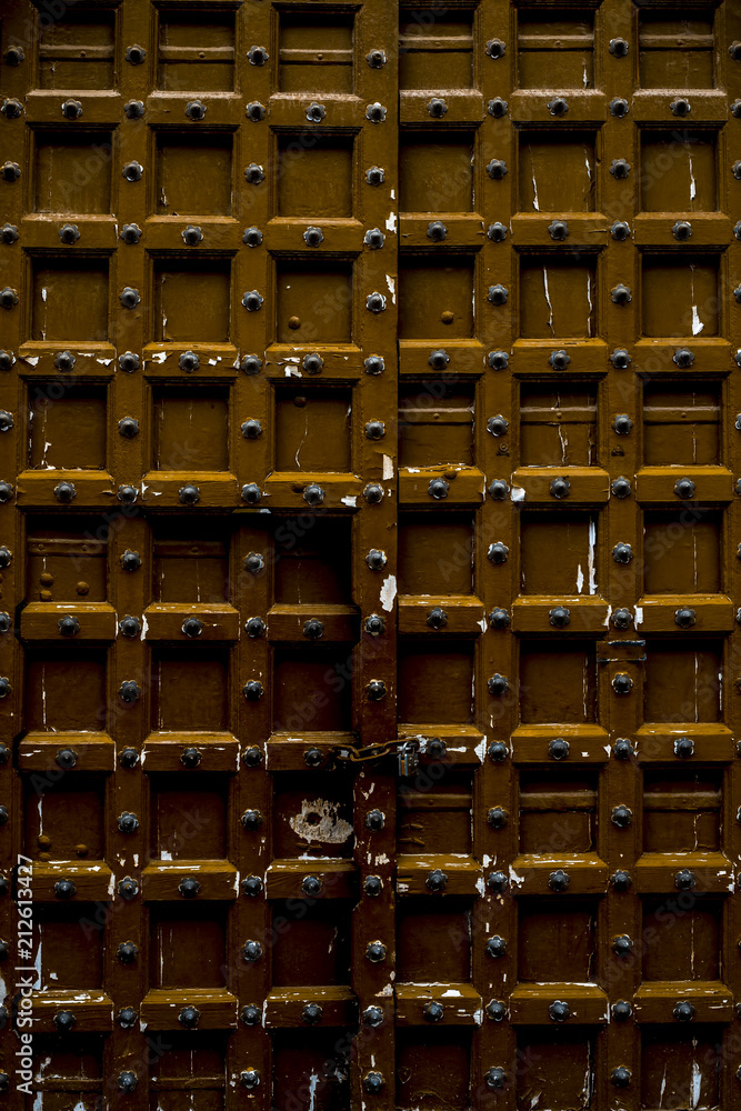 Wooden door with artistic carved designs above and in the side of the ...