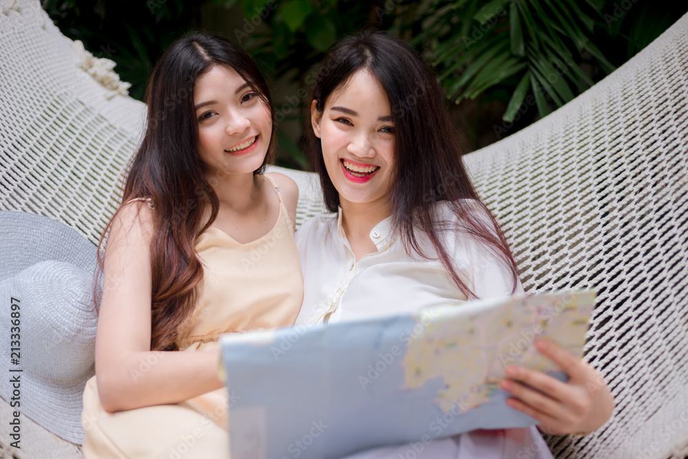 Two teenage girls who are happy to use the map to find the route of a ...