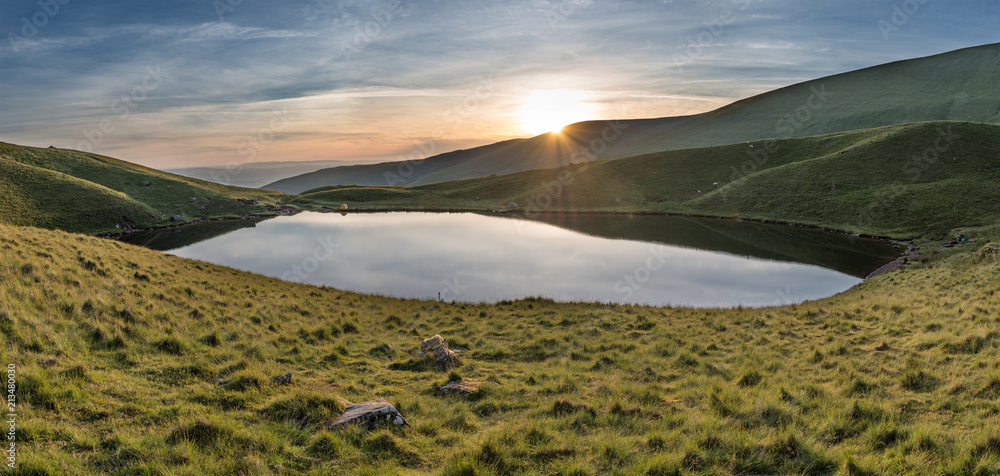Stunning colorful Summer sunrise landscape by Llyn Cwm Llwch lake in ...