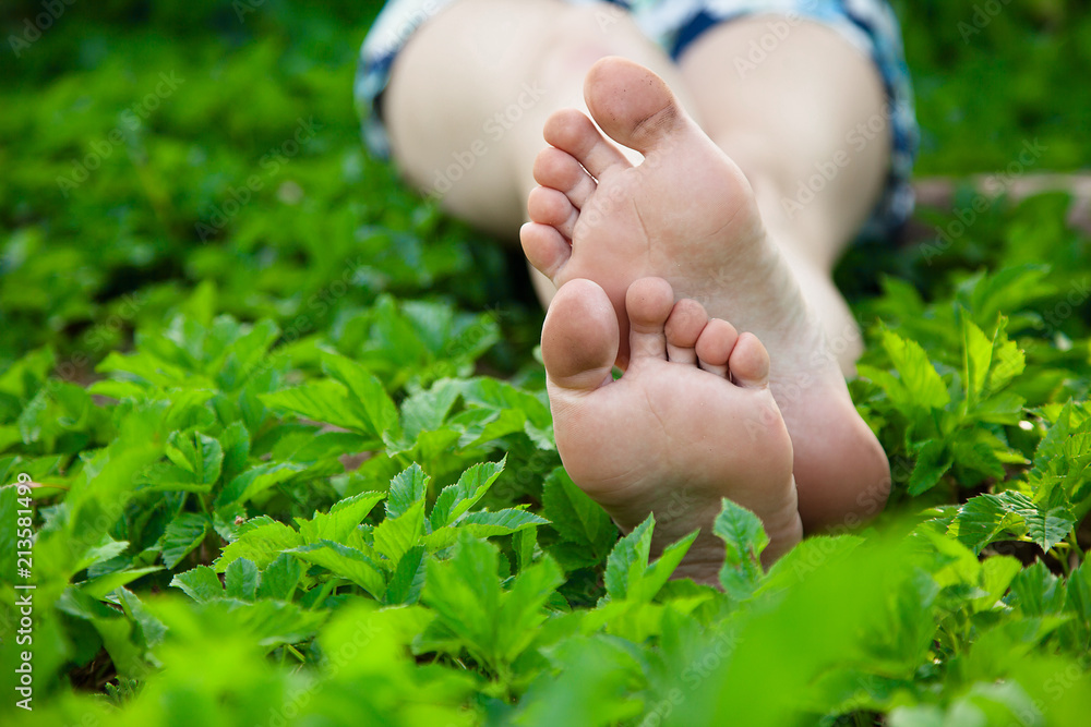 Young adult feet resting on the grass Stock Photo | Adobe Stock
