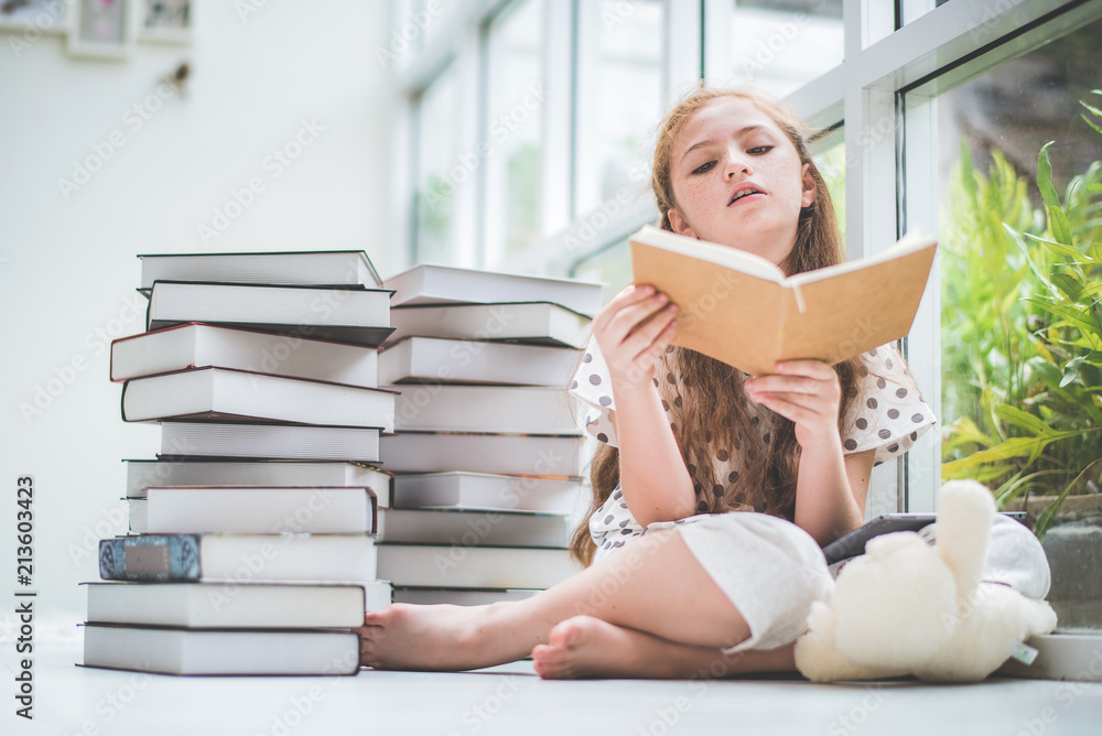 little cute girl bored to read a book at home, education concept Stock ...
