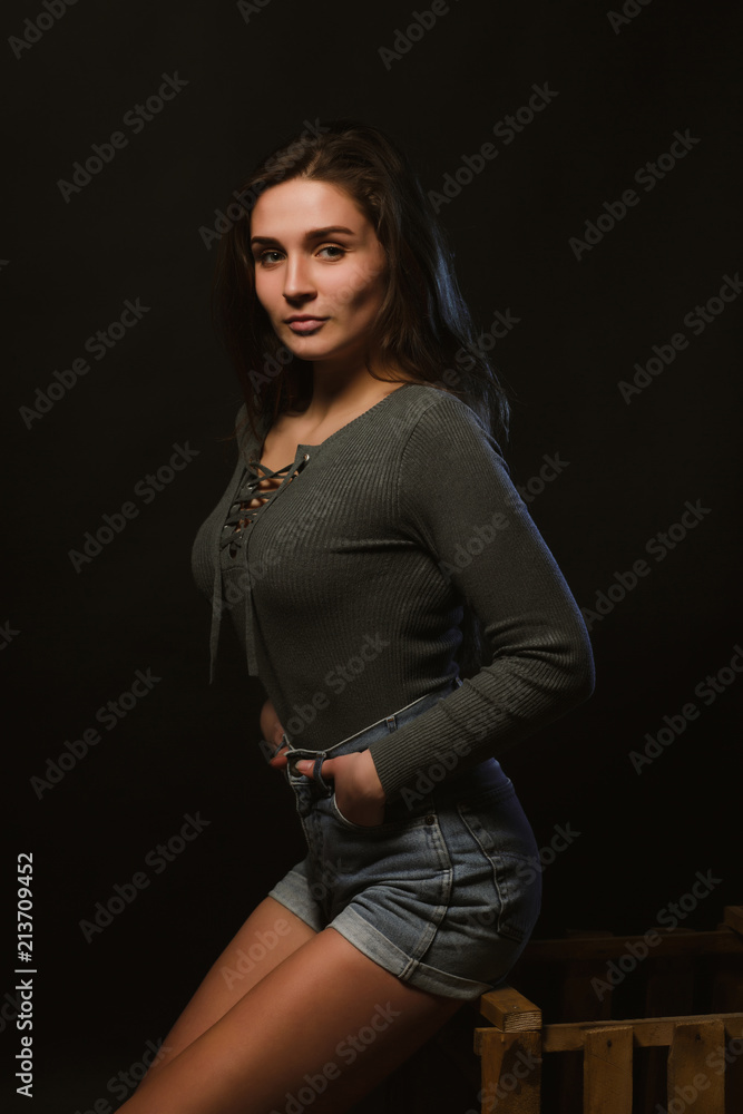 Fashion model test shoot of gorgeous girl posing in dark studio dressed ...