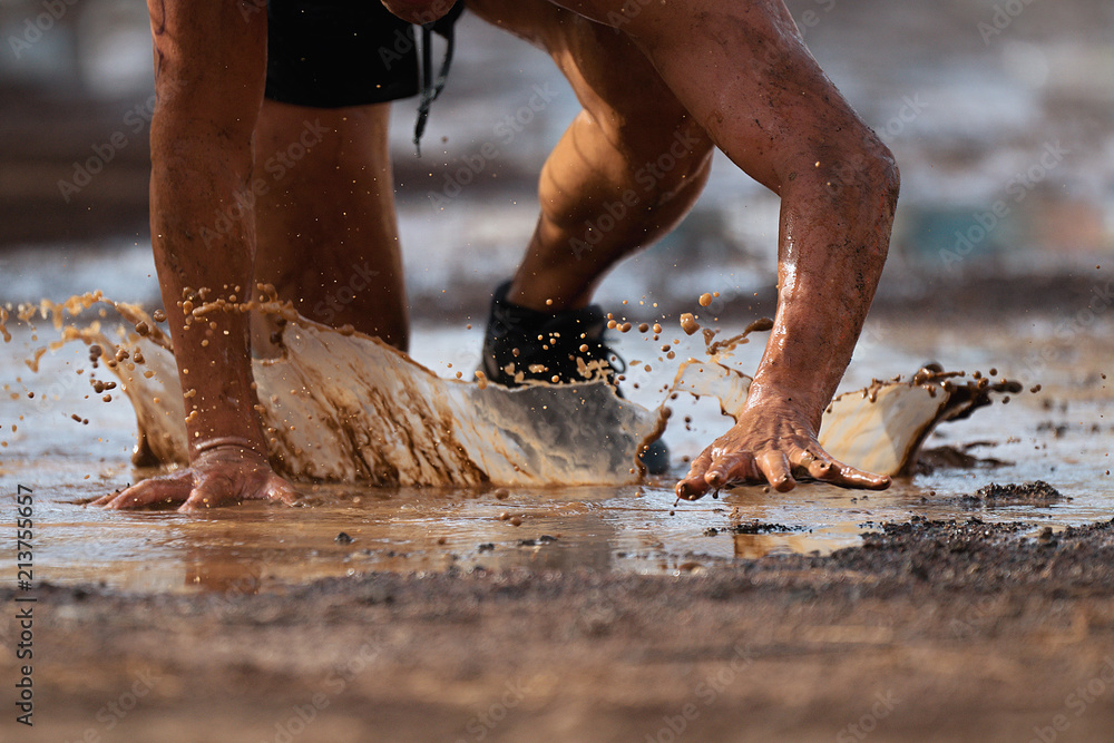 Foto de Stock Mud race runners.Crawling,passing under a barbed wire ...