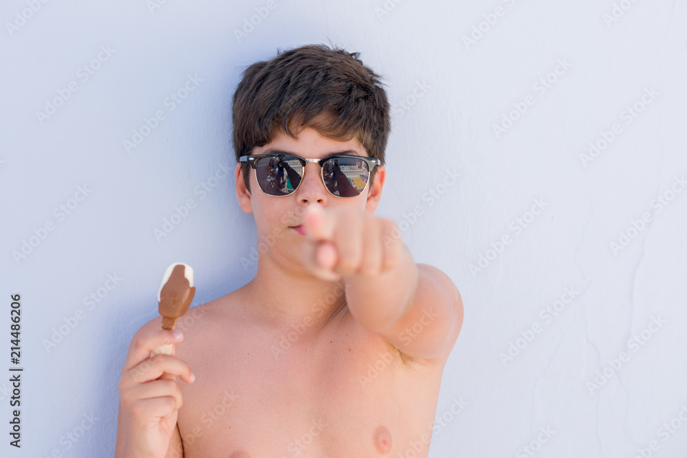 Young child on holidays eating ice cream pointing with finger to the ...