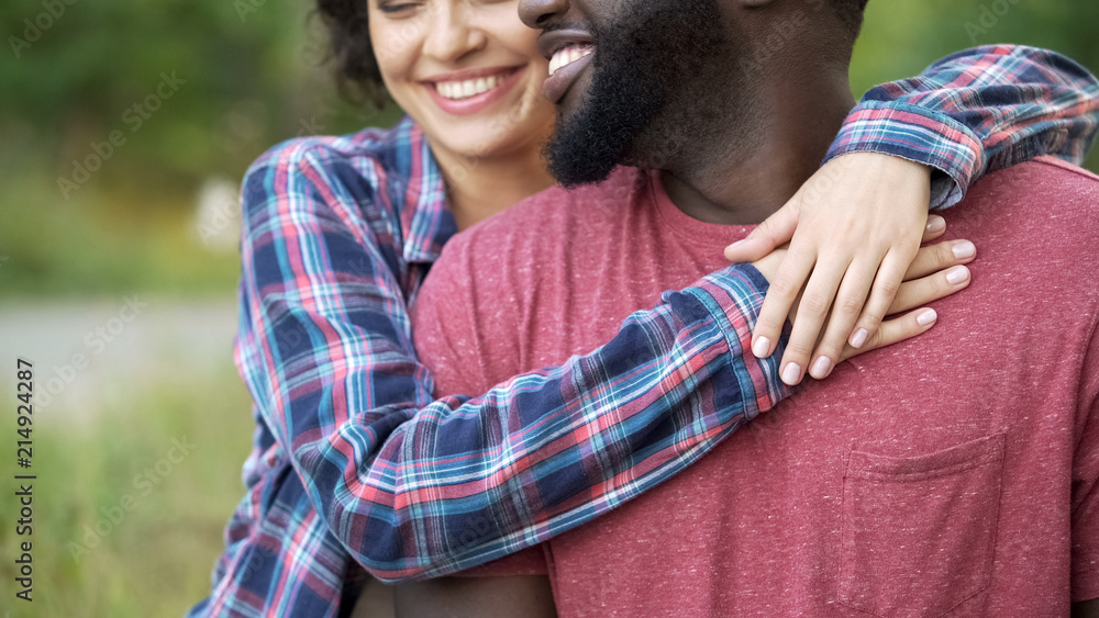 Black man and white woman smiling and tenderly hugging, happy people ...