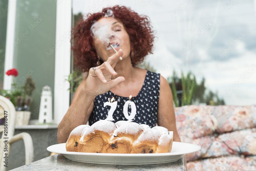 Badass senior woman smoking on a birthday cake Stock Photo | Adobe Stock