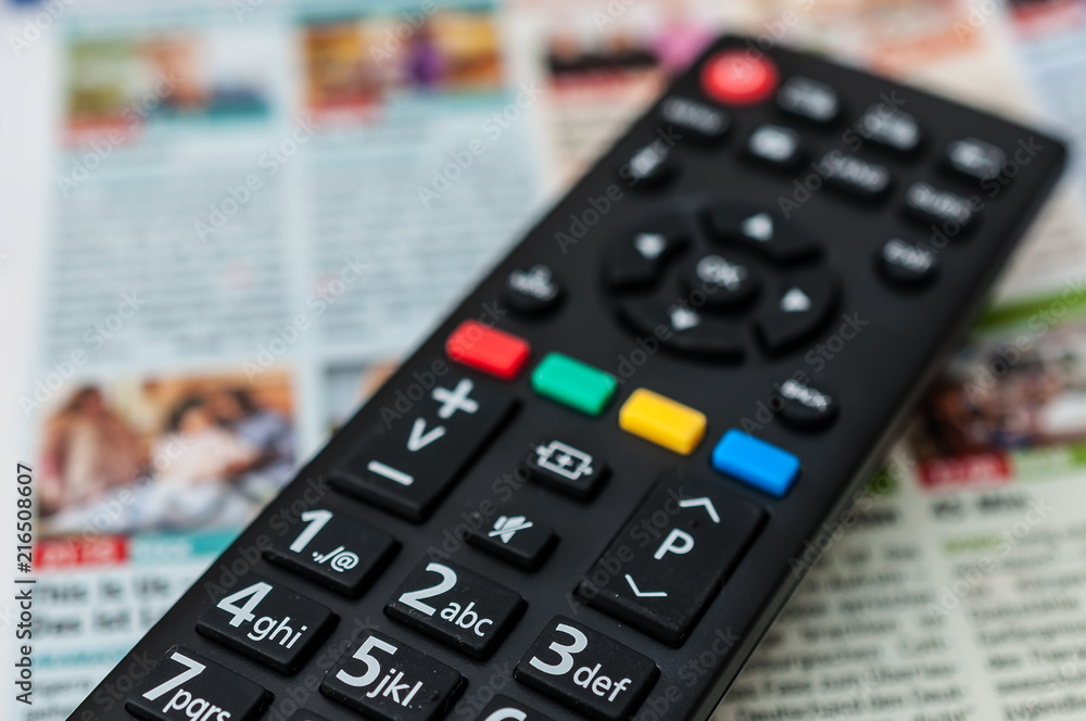 Stock-Foto „Fernbedienung und Fernsehzeitschrift “ | Adobe Stock