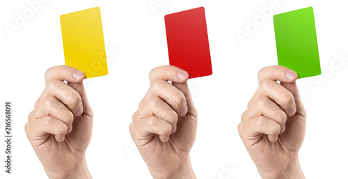 Male football (soccer) referee hand holding yellow, red and green cards ...