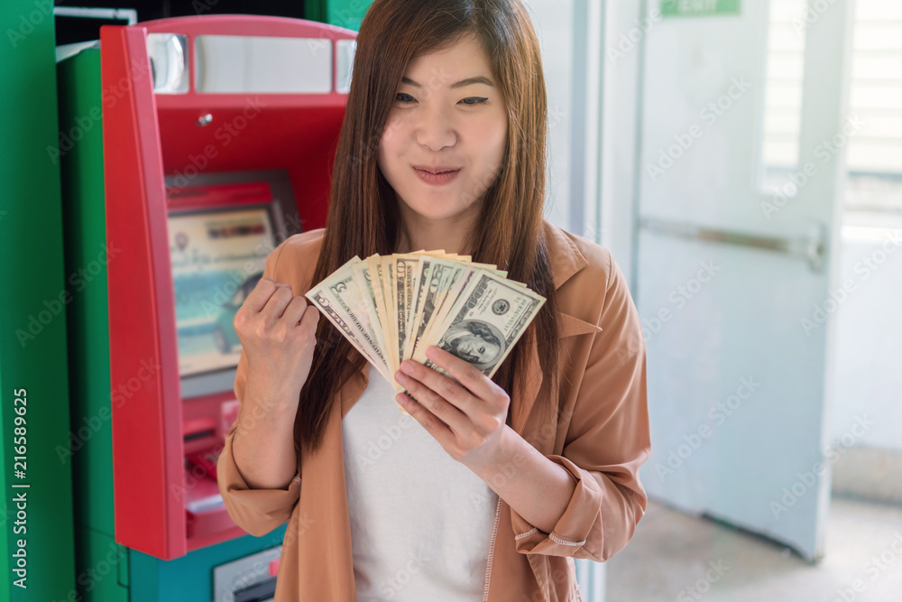 Happy asian young woman holding the dollar money with smiling action ...
