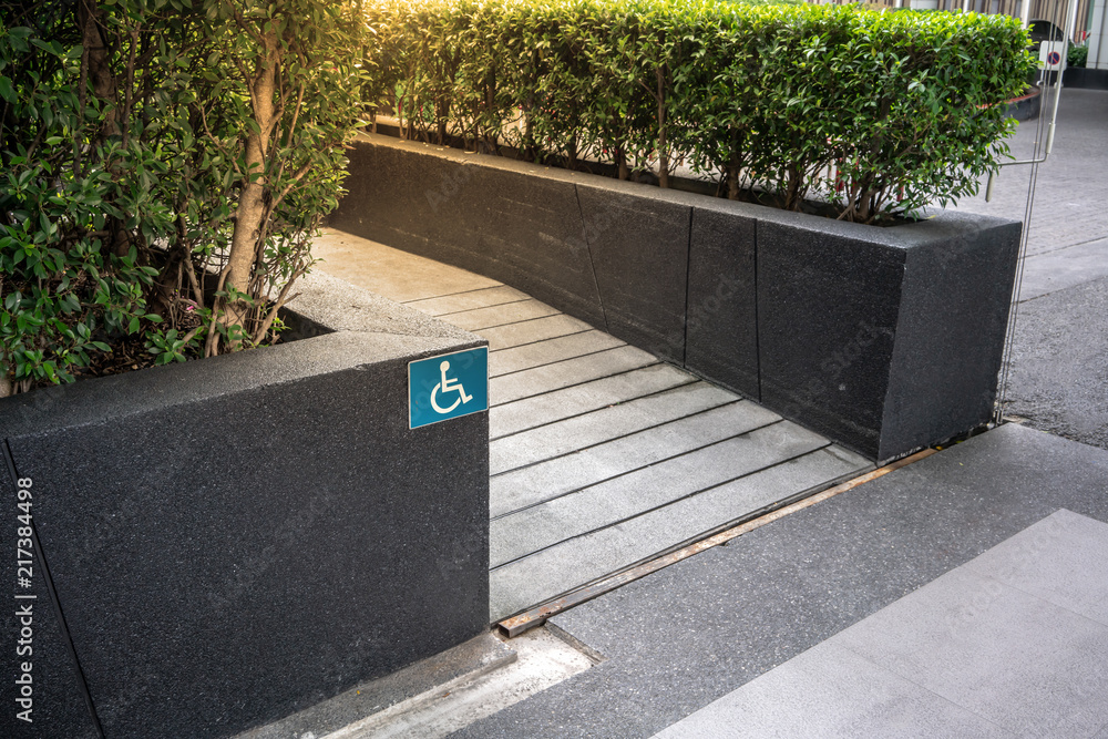Ramped access, using wheelchair ramp with information sign on floor ...