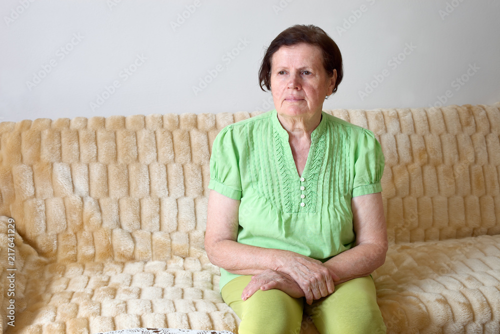 Ältere Frau sitzt auf dem Sofa の Stock フォト | Adobe Stock