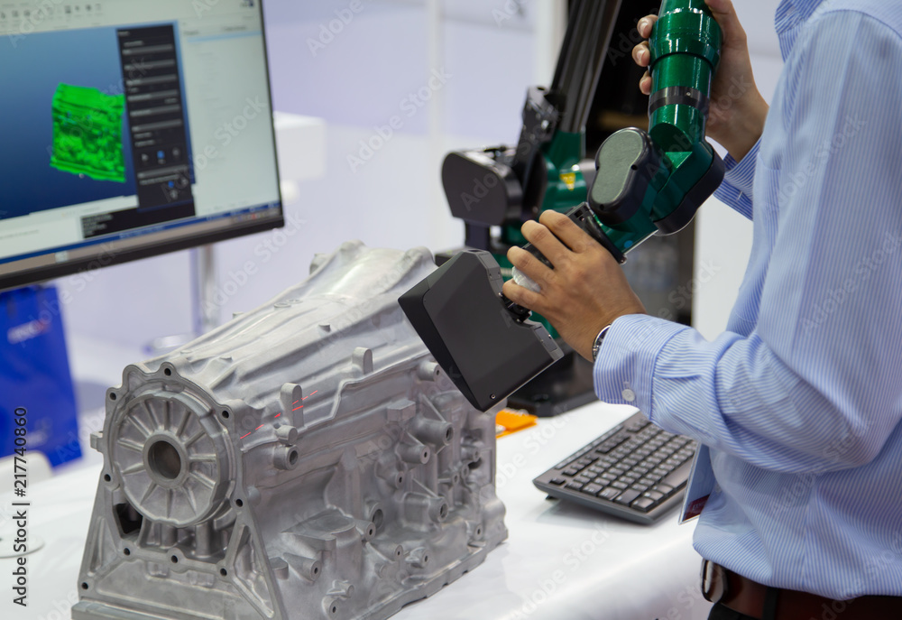 Industrial professional using CMM laser scanner to inspect engine part ...