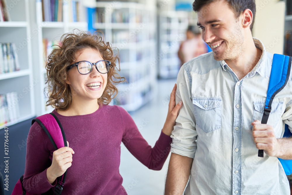 Cheerful excited curly-haired girl in glasses touching boys shoulder ...