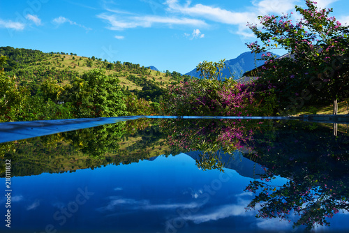 Infinity pool. Luxury relaxing mountains view, deep blue sky, green ...