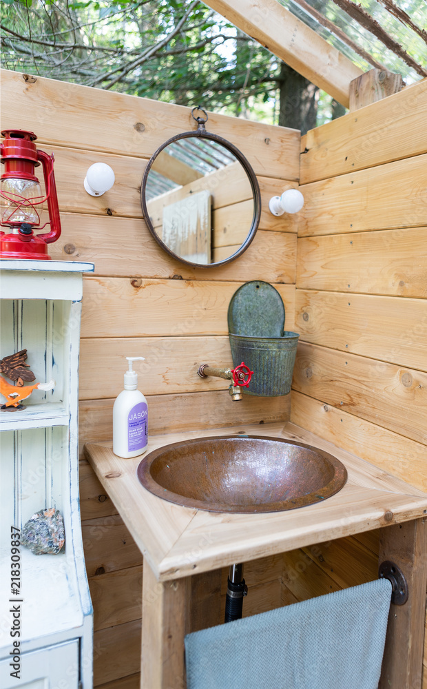 Outdoor shower and composting toilet stall at a glamping site Stock ...