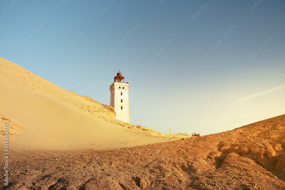 Beautiful sunset view of the lighthouse and sand desert dunes and ocean ...