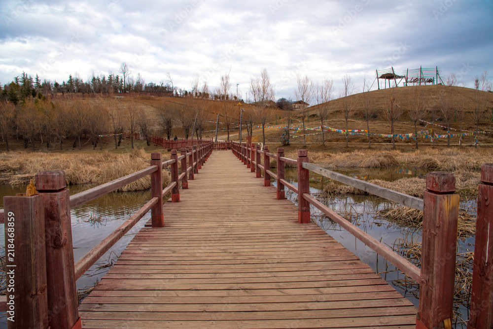 Long wooden bridge crossing over and path to slope grass Stock Photo ...