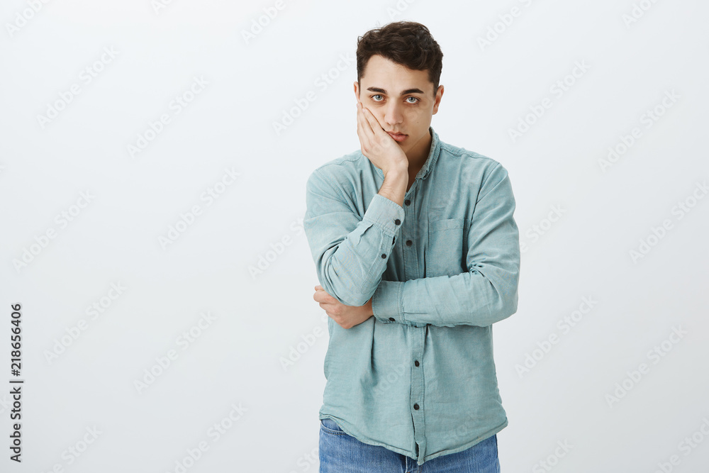 Portrait of bored pissed attractive male student in shirt, leaning face ...