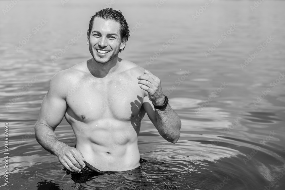 Handsome man in water, sexy guy showing muscular fit body. Concept os ...