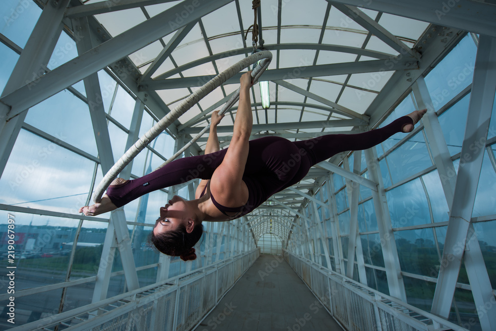 An air gymnast makes a Russian splits on an air hoop suspended on a ...