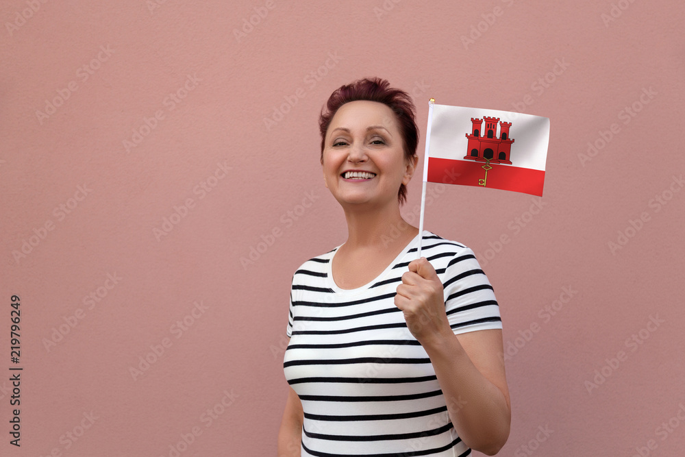 Gibraltar flag. Woman holding Gibraltar flag. Nice portrait of middle ...