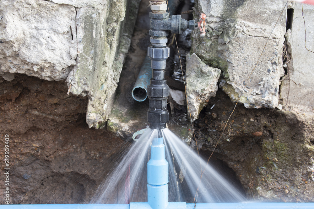 Water pipe break .Exposing a burst water main, focused on the spraying ...