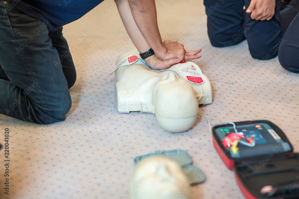 CPR training using and an AED and bag mask valve on an adult training ...