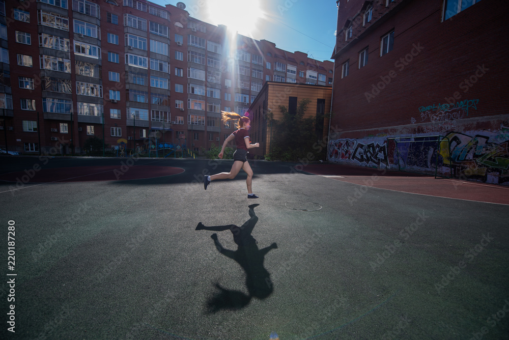 Red-haired young girl runs in the stadium. Student delivers standards ...