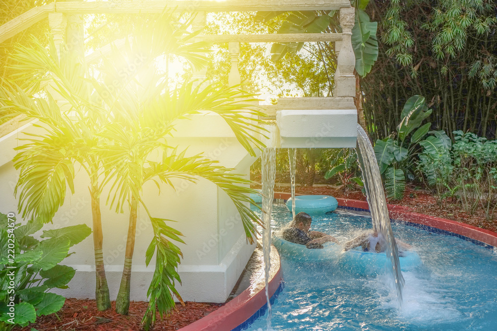 Lazy river pool with waterfall. People have fun with river Run ...