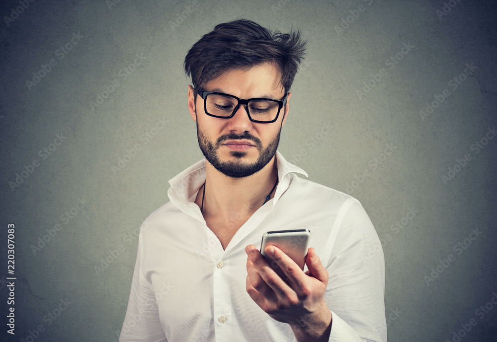 Angry disgusted man using smartphone Stock Photo | Adobe Stock