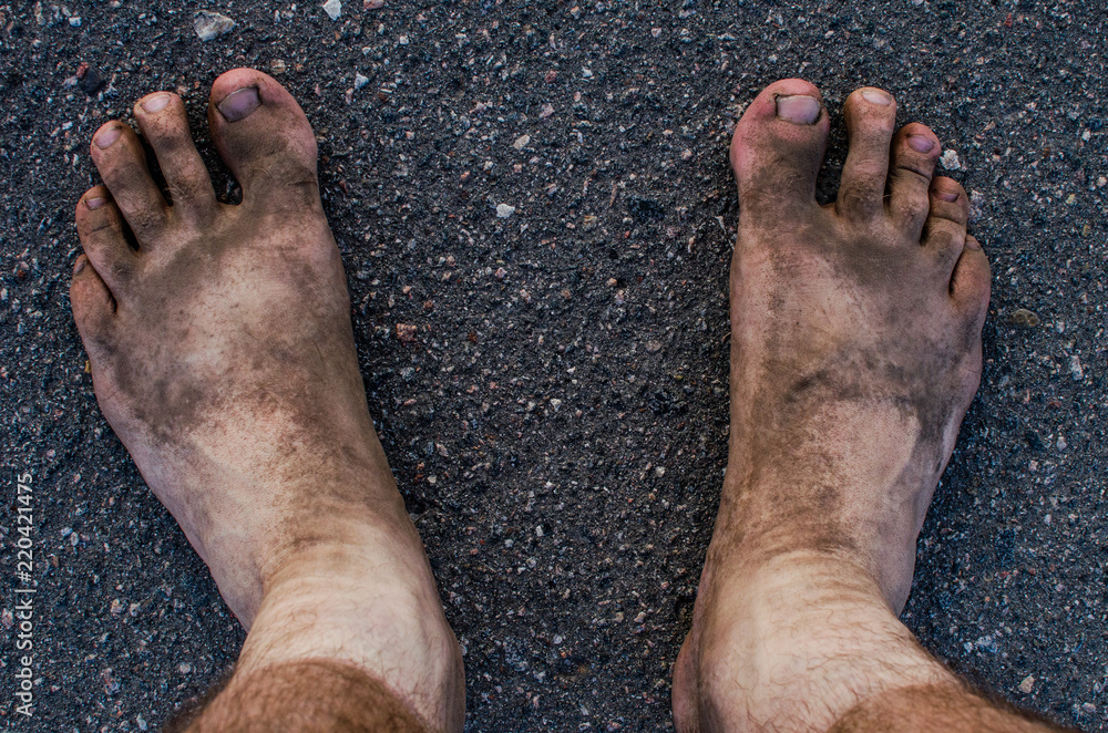 A man stands barefoot with dirty feet. Dirty toes. Dirty people after ...