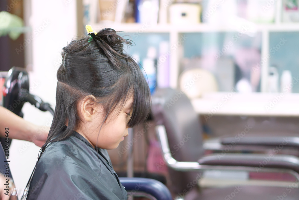 Asian children cute or kid girl haircut because long hair in salon or ...