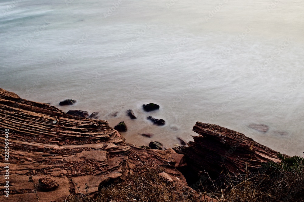 una roca y el mar detrás con larga exposición Stock Photo | Adobe Stock