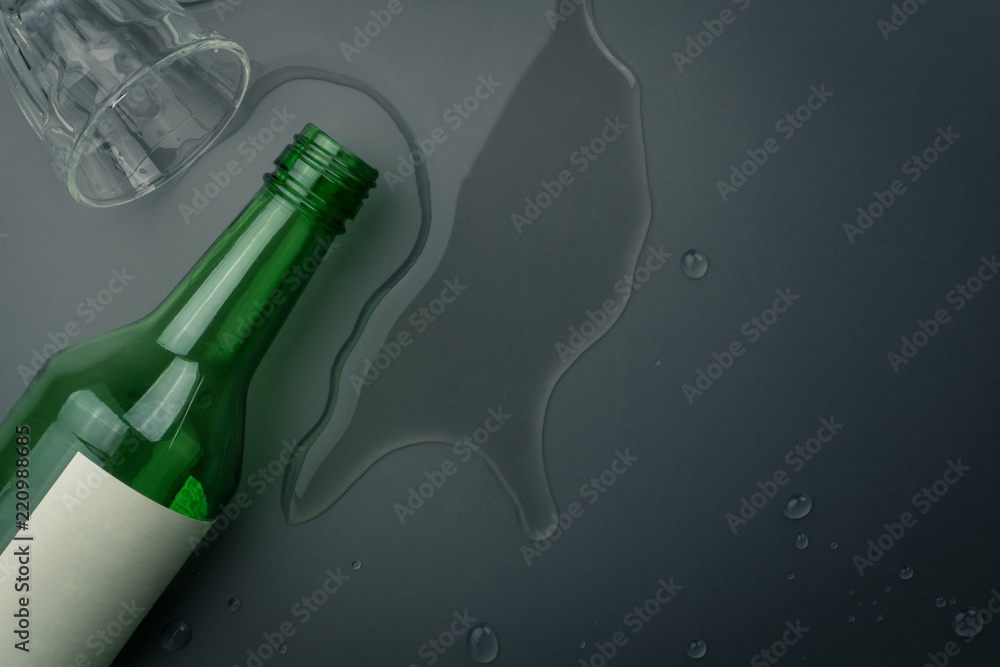 top view of soju bottle with glass of soju spilled on the table. Soju ...