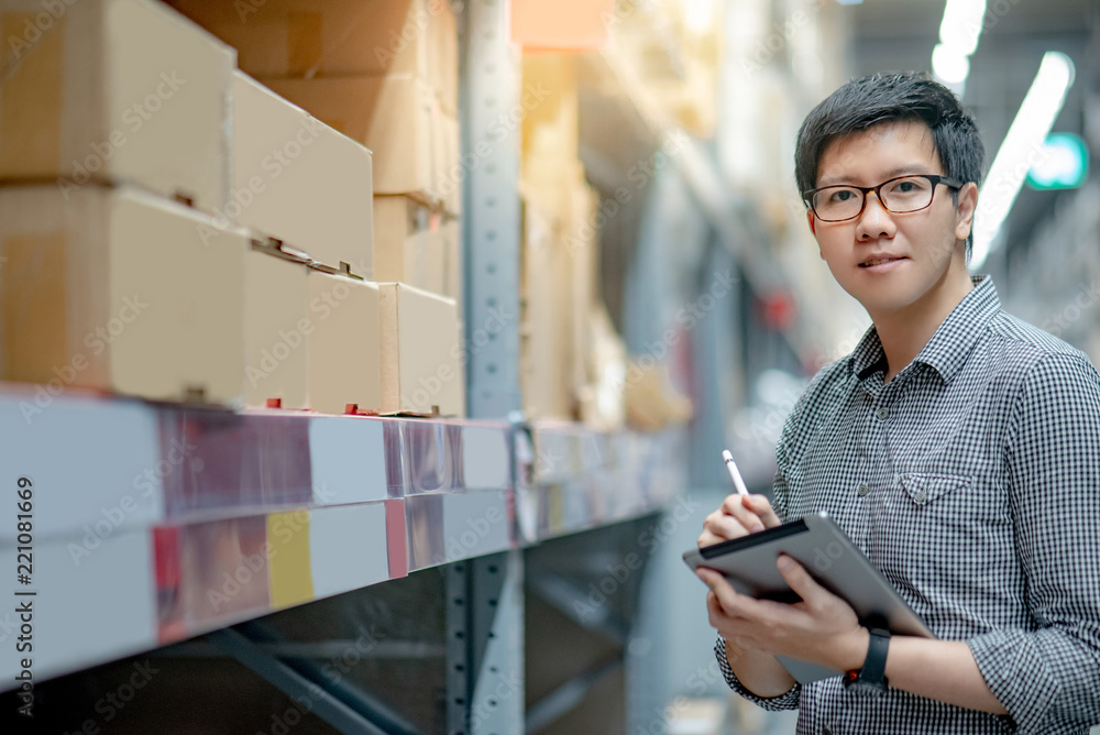 Young Asian man worker doing stocktaking of product in cardboard box on ...